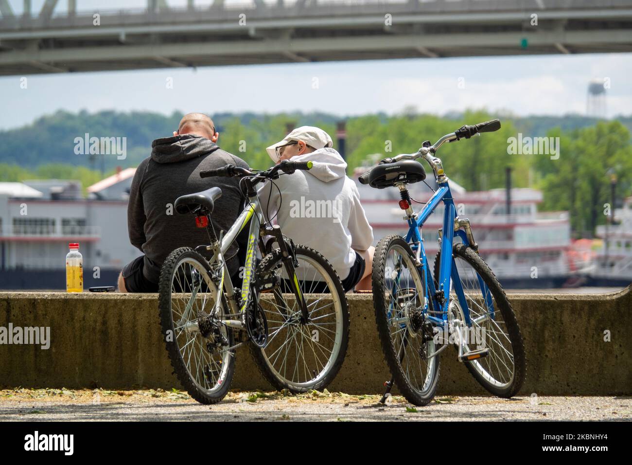 A father and son rest during their bike ride along the Ohio River in ...