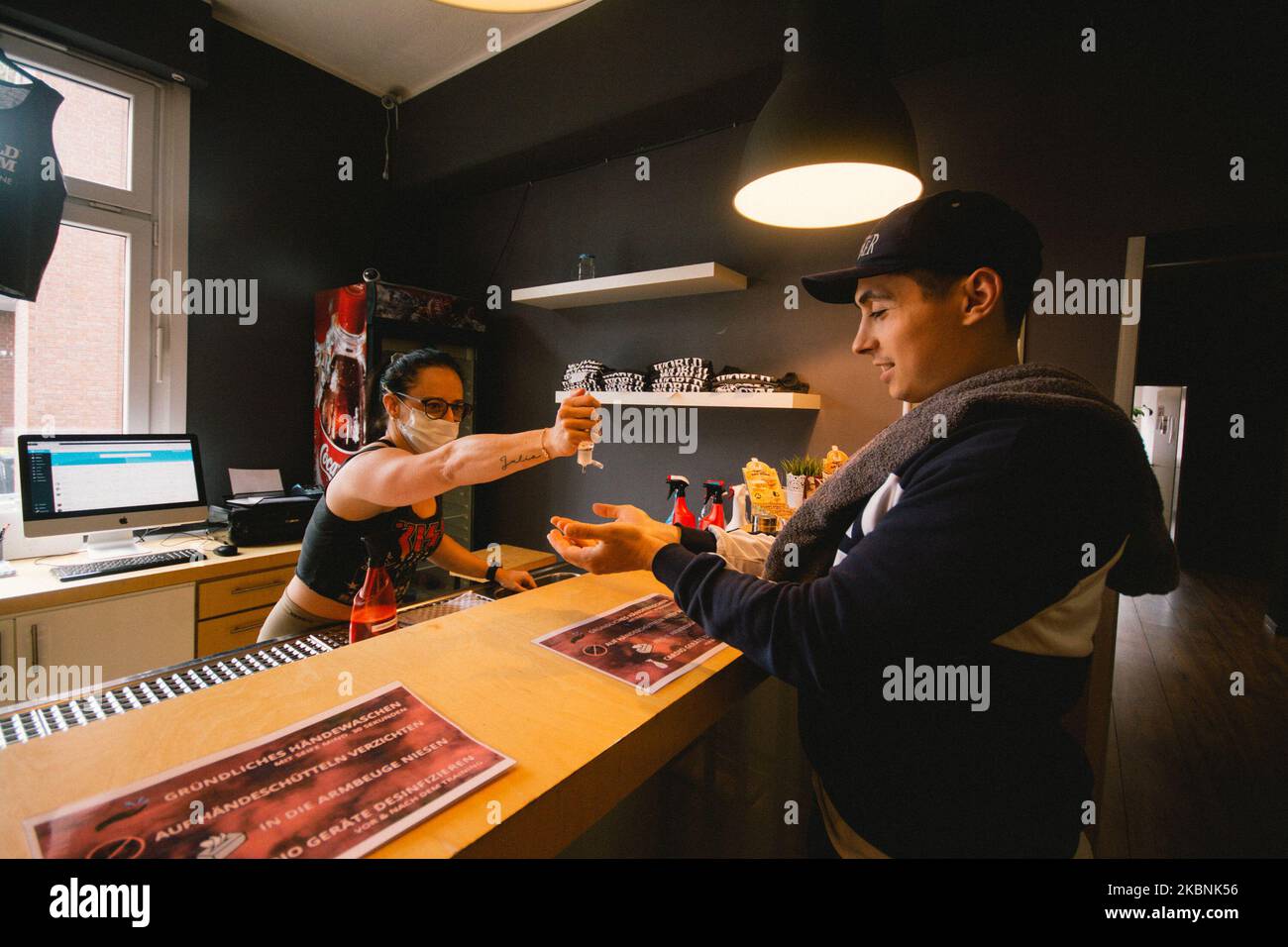 World Gym Cologne staff gives customer a hand sanitizer before entering ...