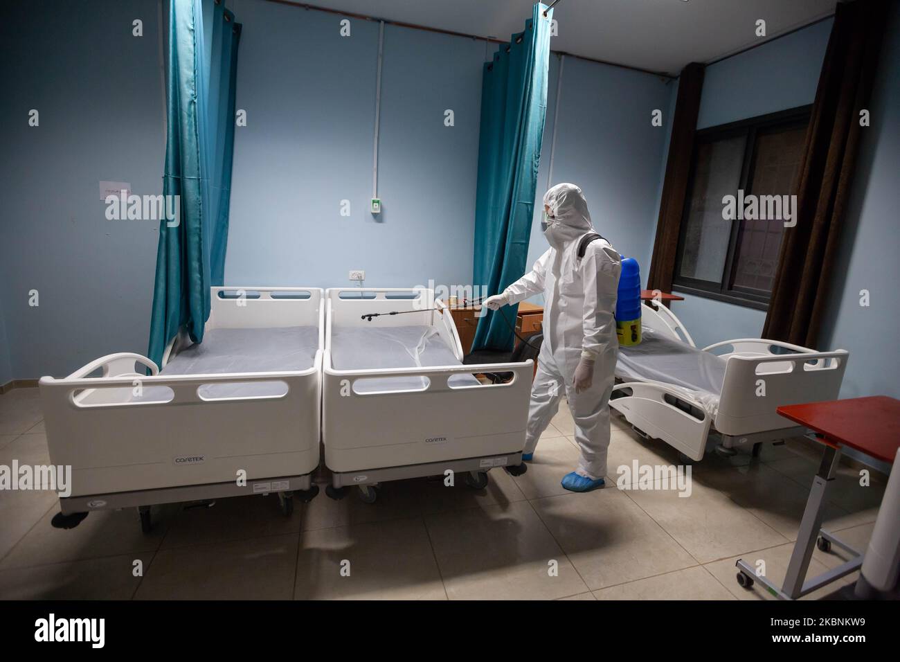 Palestinian health staffs, wearing protective gear, sterilize a room at ...