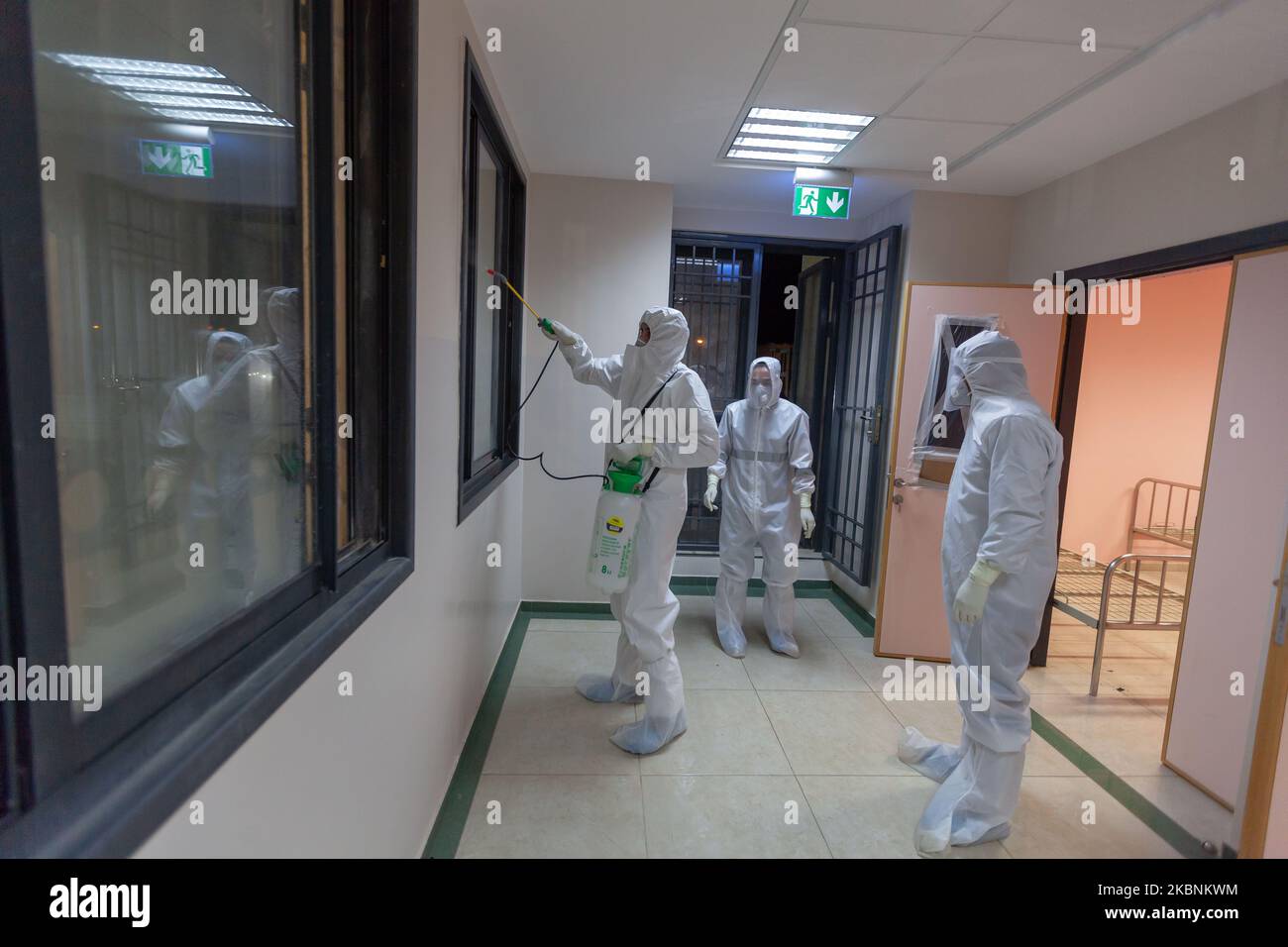 Palestinian health staffs, wearing protective gear, sterilize a room at ...