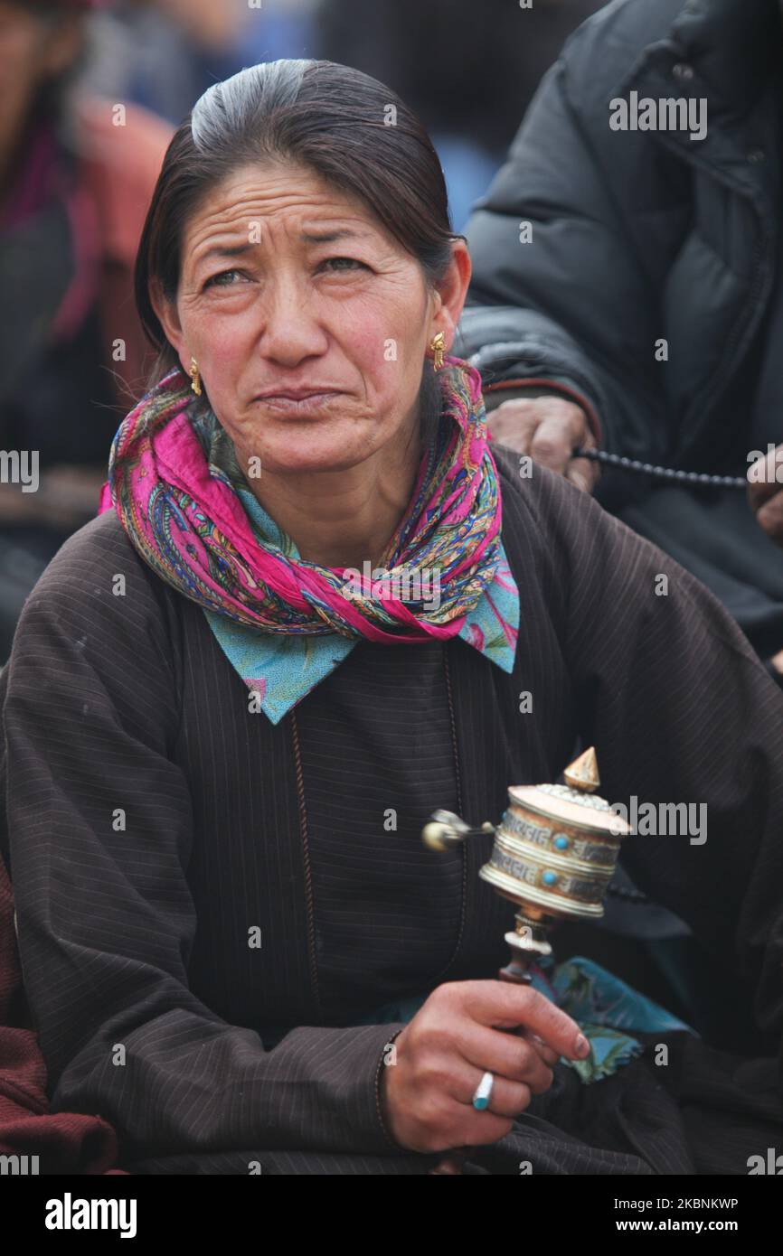 Ladakhi woman turns a hand-held prayer wheel as she watches Buddhist ...