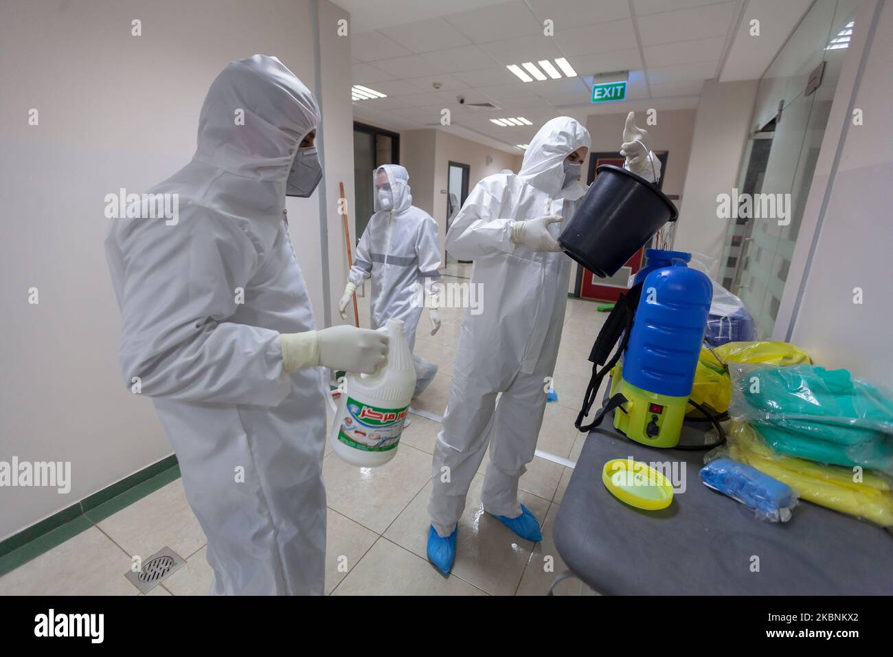 Palestinian health staffs, wearing protective gear, sterilize a room at ...