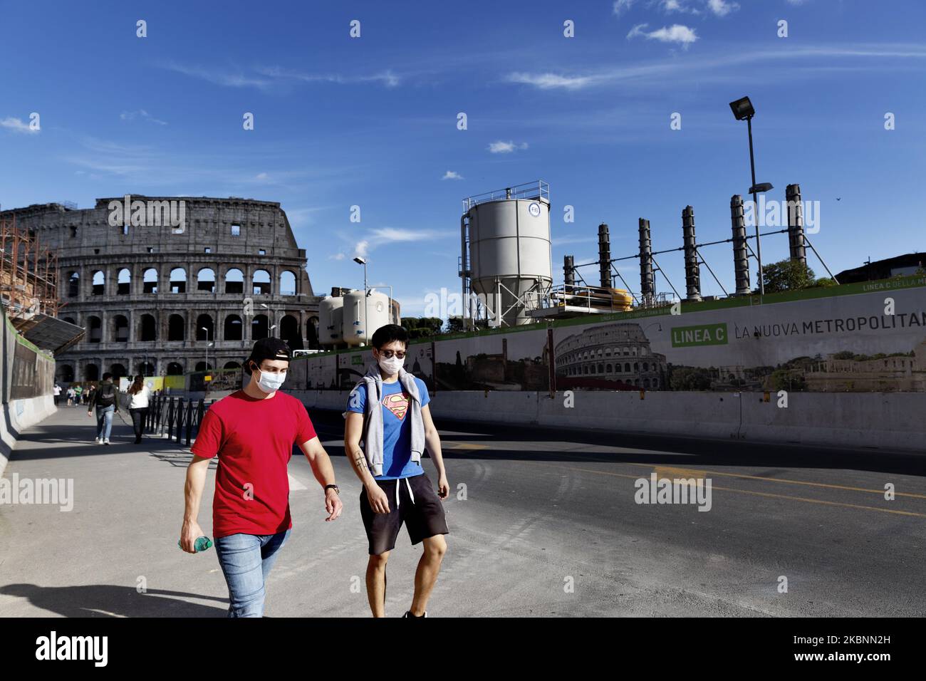A group of guys walking in front of Colosseo during the ‘Fase 2’ (phase ...