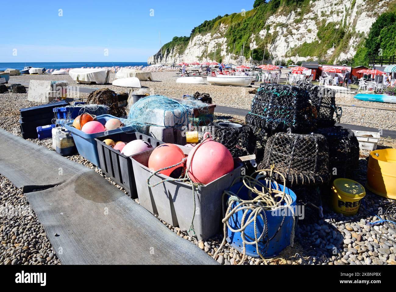 Lobster pots and fishing equipment on the beach with Lyme Bay and ...