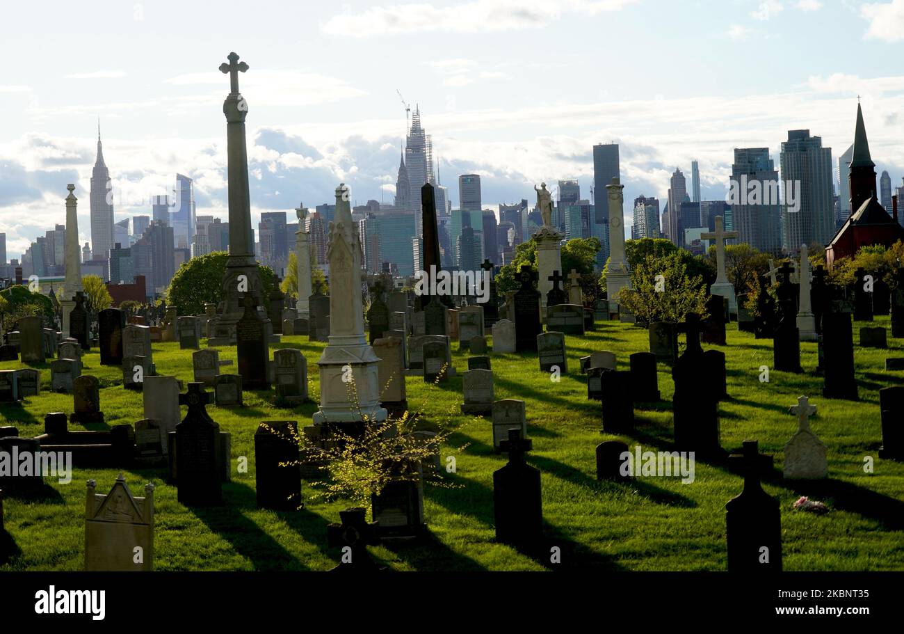 Tombstones are seen in a New York City cemetery against the background ...