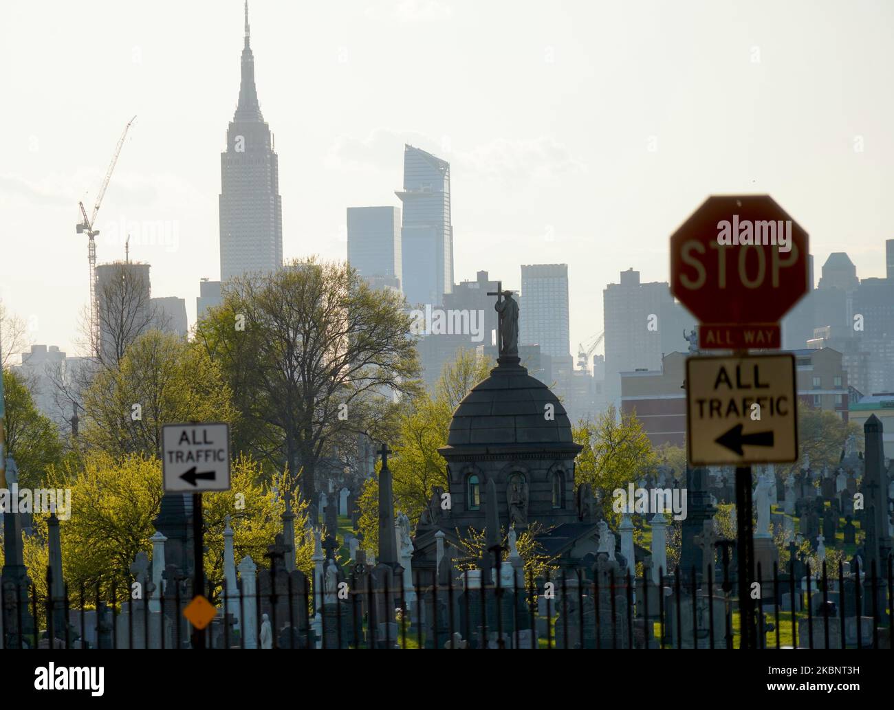 Tombstones are seen in a New York City cemetery against the background ...