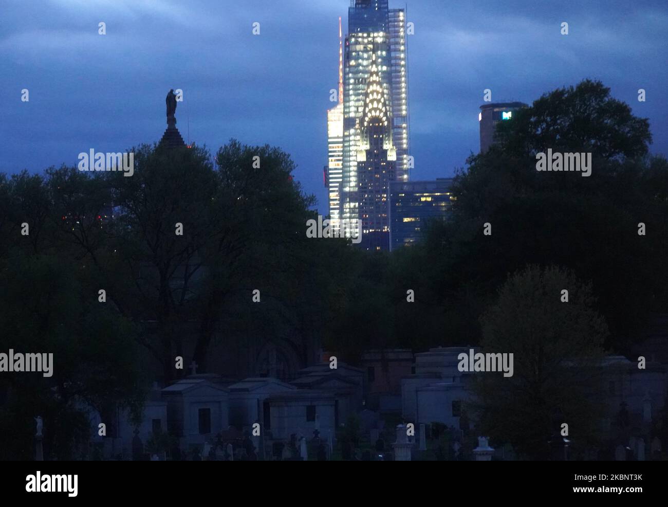 Tombstones are seen in a New York City cemetery against the background ...