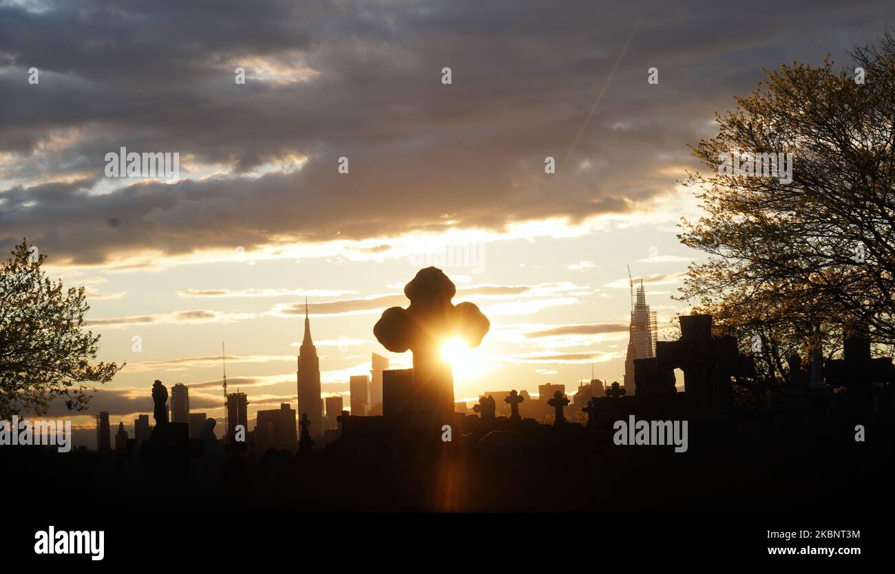 Tombstones are seen in a New York City cemetery against the background ...