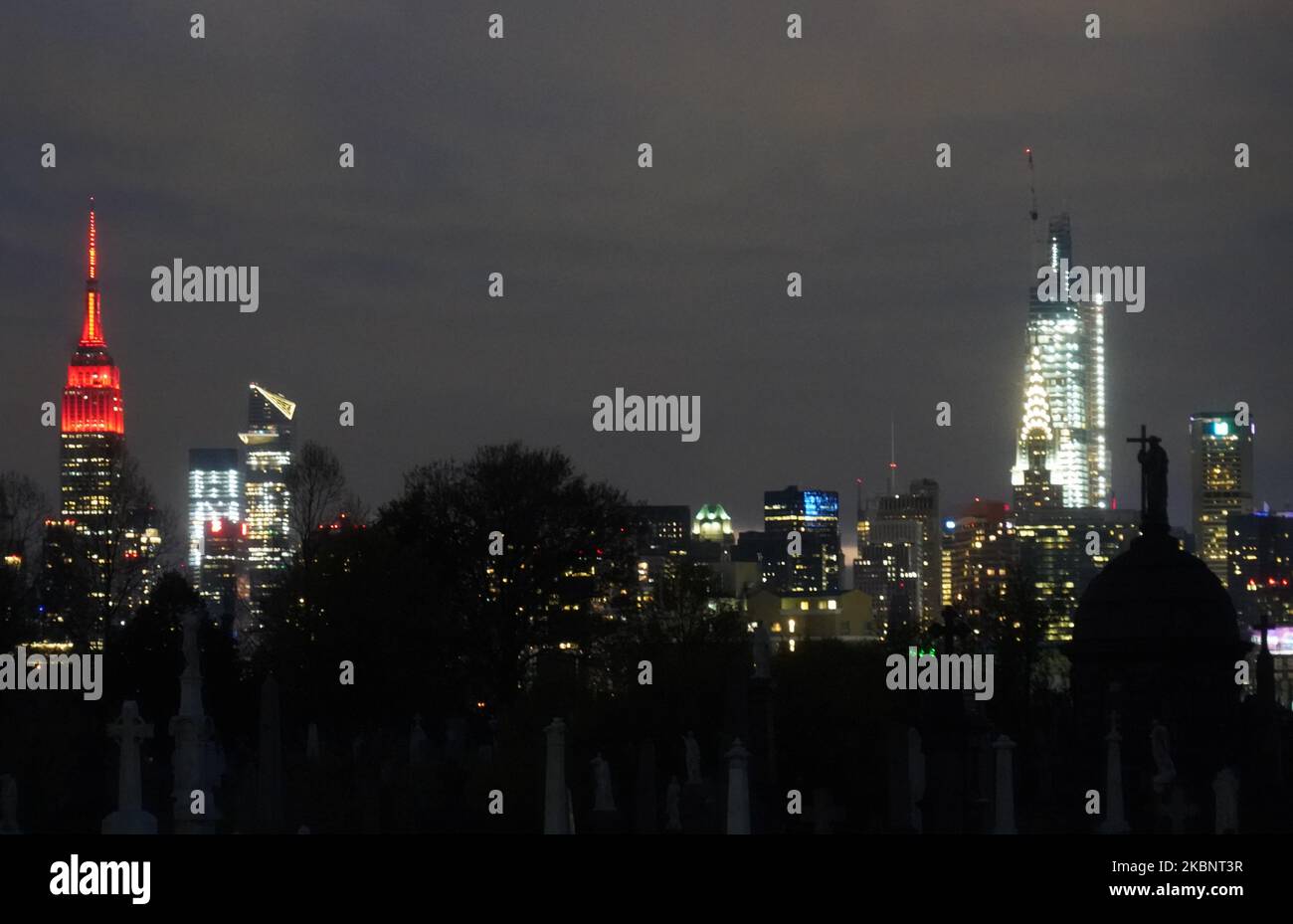 Tombstones are seen in a New York City cemetery against the background ...