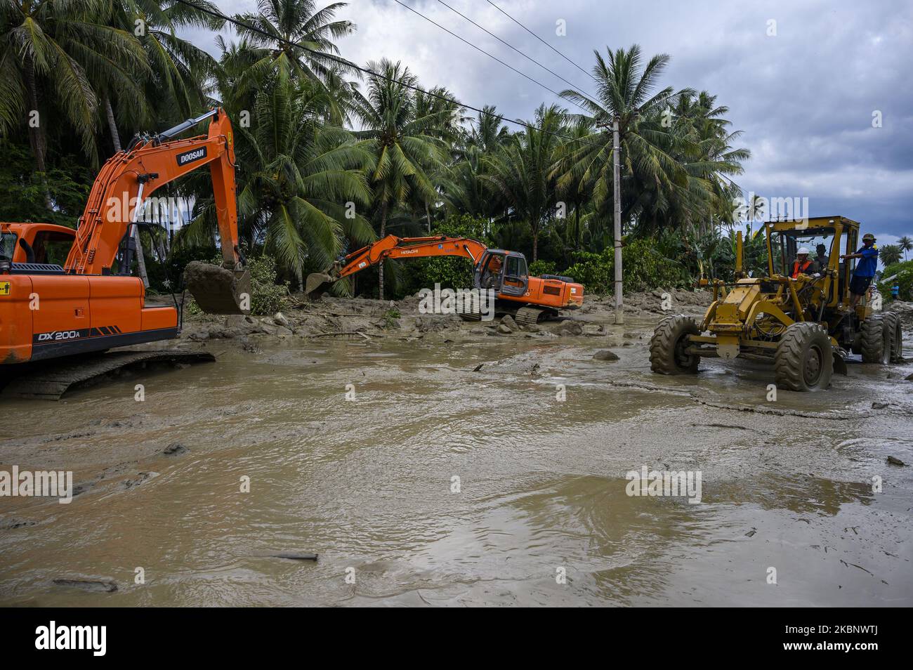 Heavy equipment operators tried to get rid of mud that filled the road ...