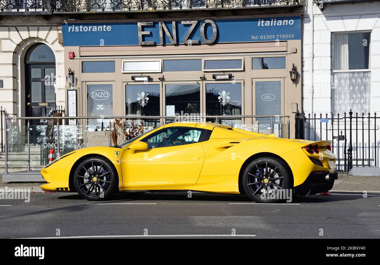 Yellow Ferrari F8 Spider parked outside the Enzo restaurant along the ...
