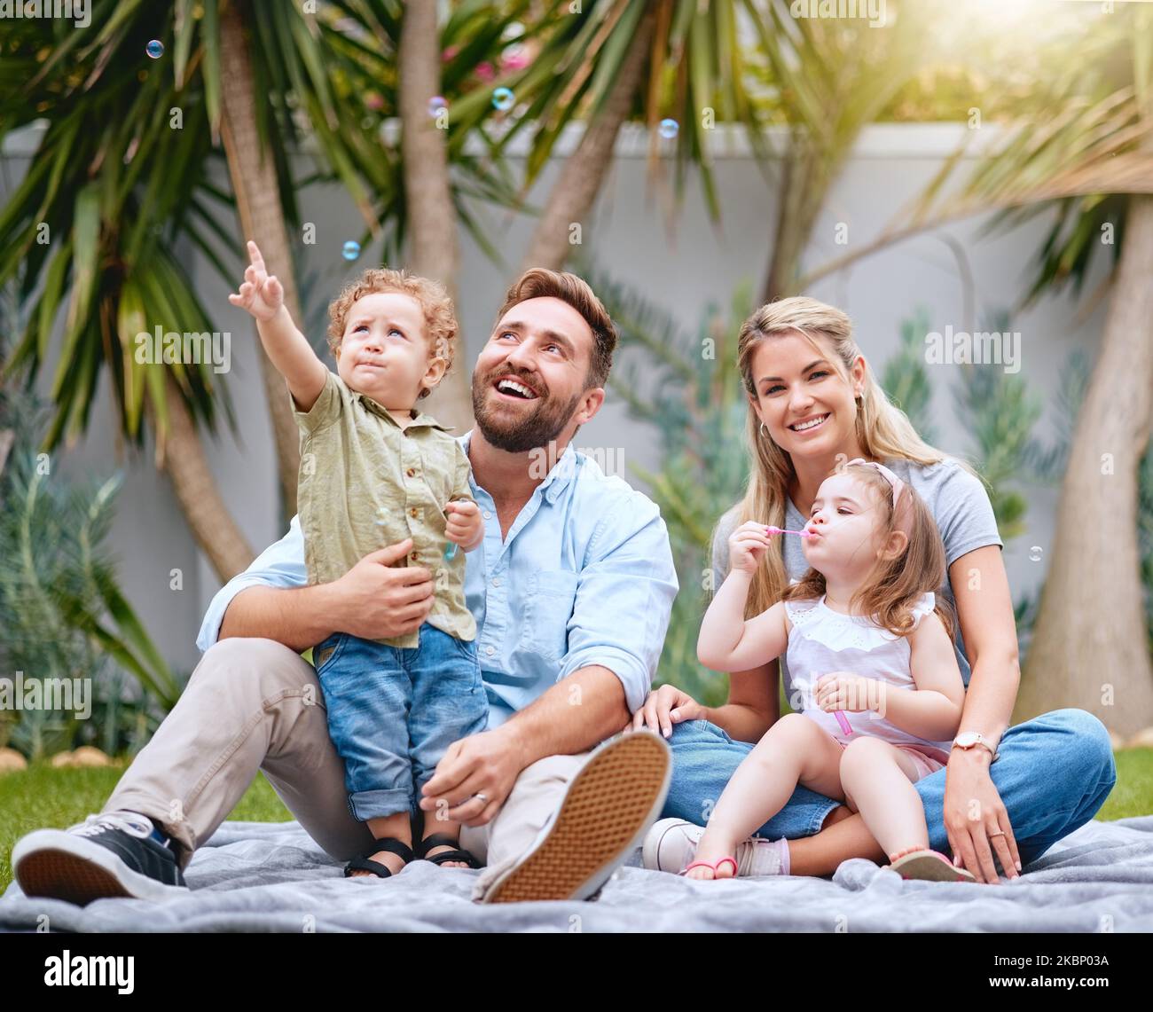 Family garden, bubbles and children with parents together with a smile ...