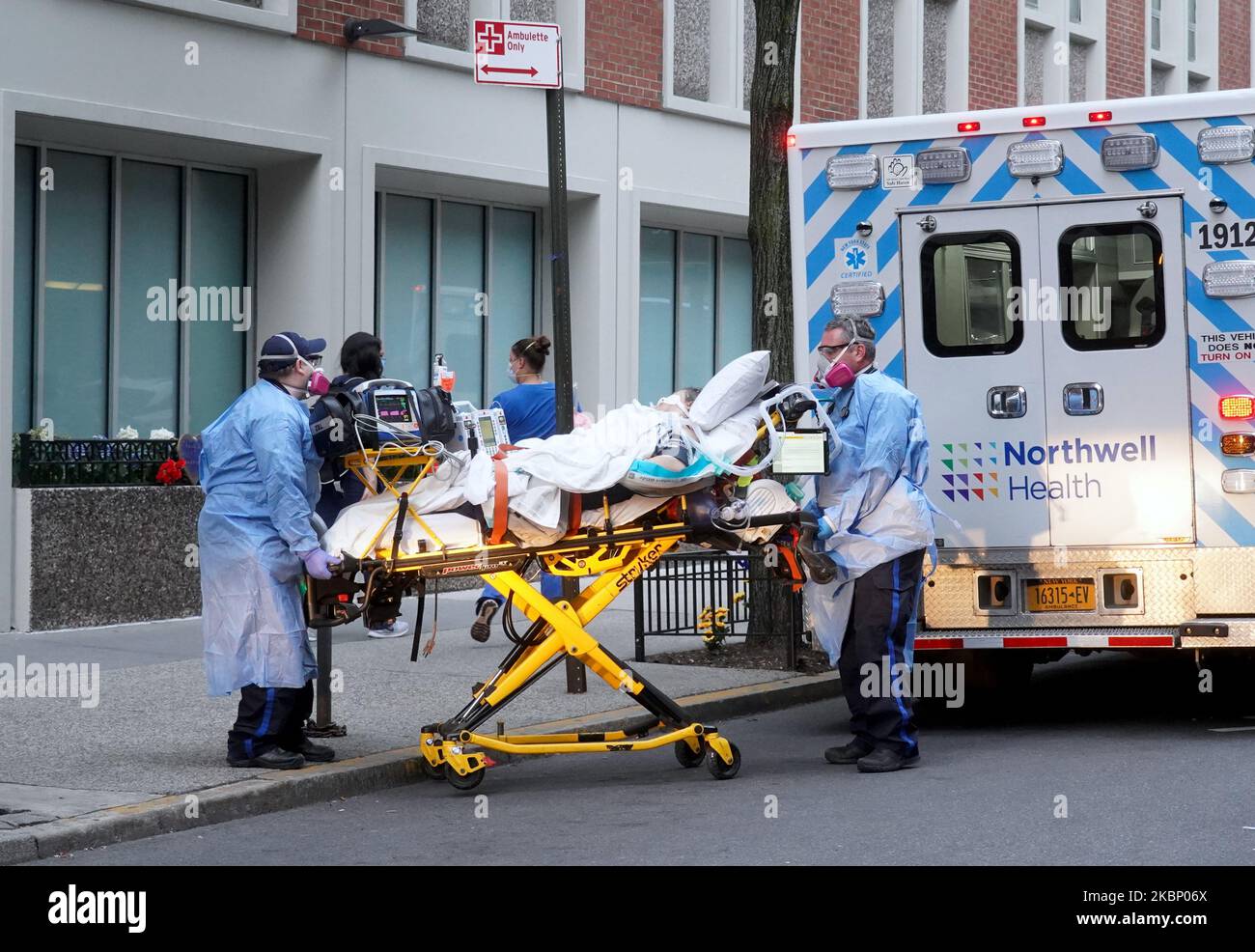 Emergency medical personnel transport a patient from an ambulance to ...