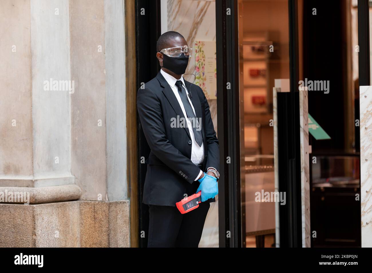 Staff members give hand-sanitizing gel and test customer’s temperature ...