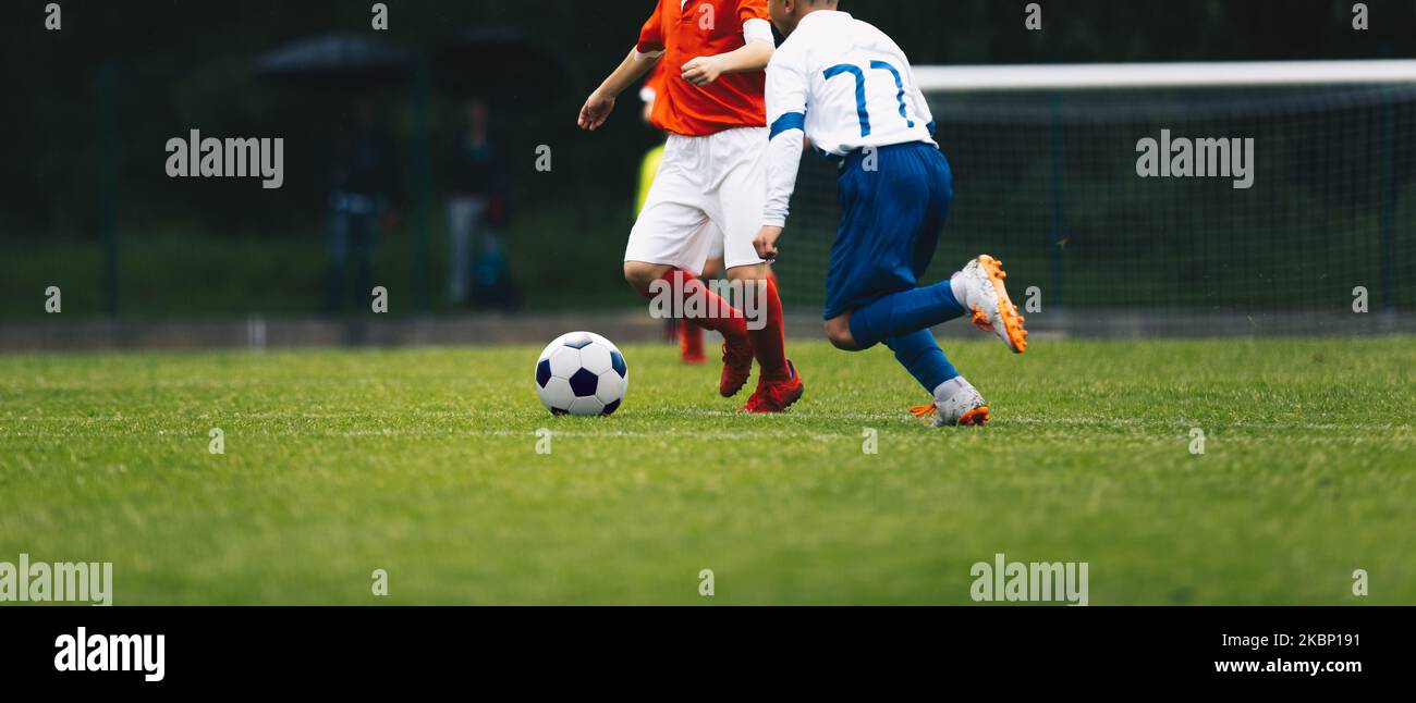 Two boys kicking soccer ball. Young teenage boys playing sports ...