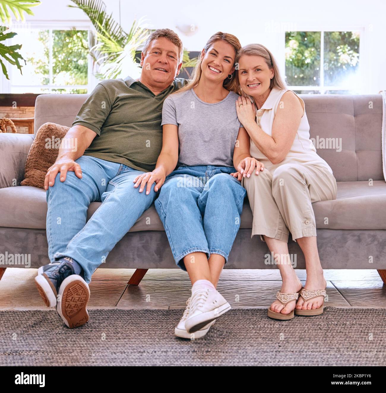 Family, portrait and grandparents with woman on sofa in home, bonding and enjoying quality time ...