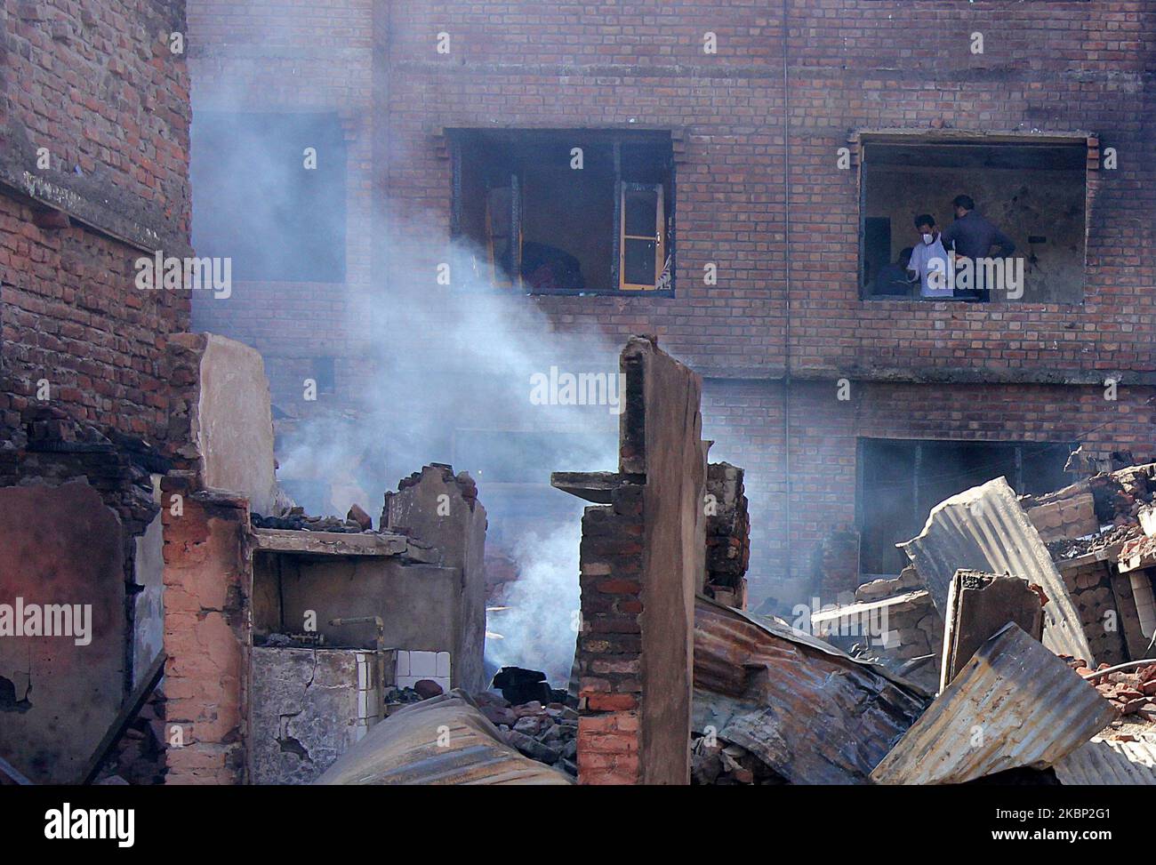 Residents inspect damaged house which was destroyed during the gun ...