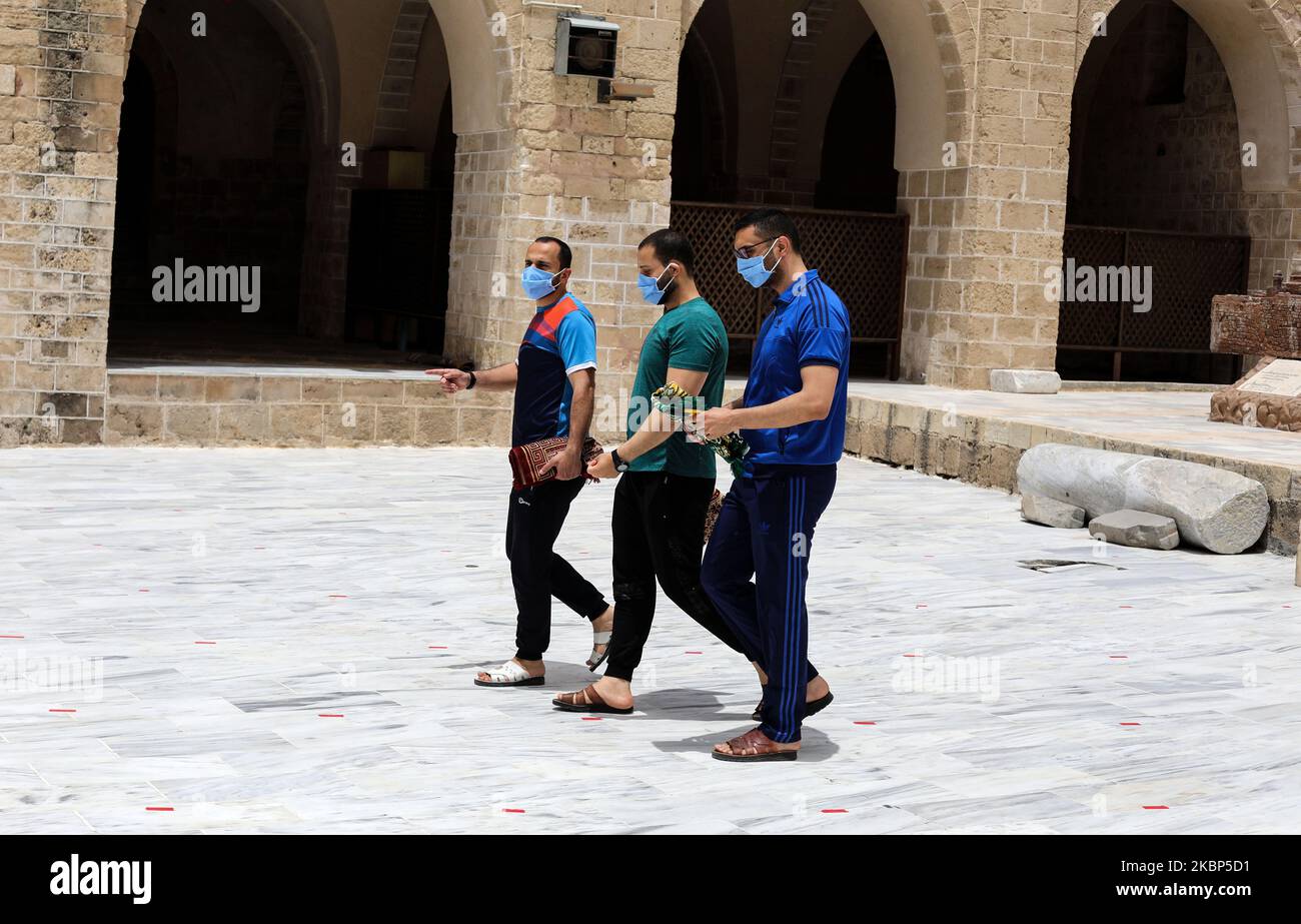 Palestinians wearing masks attend Friday prayers in a mosque as the ...