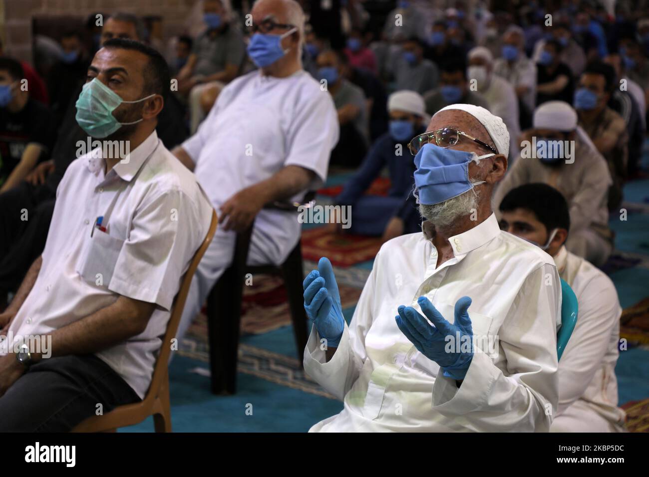 Palestinians wearing masks attend friday prayers in a mosque as hi-res ...