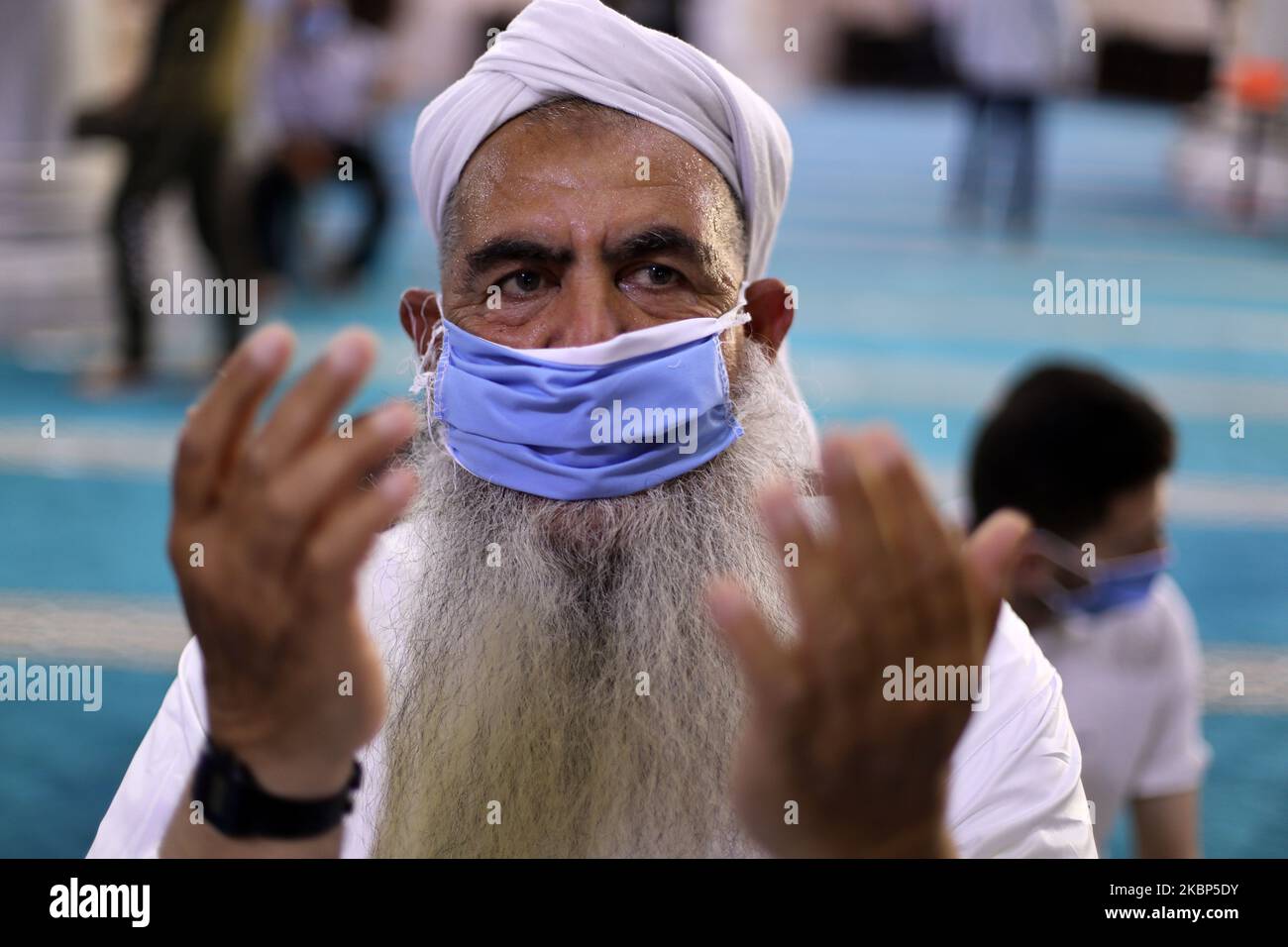 A Palestinian wears a mask attending Friday prayers in a mosque with ...