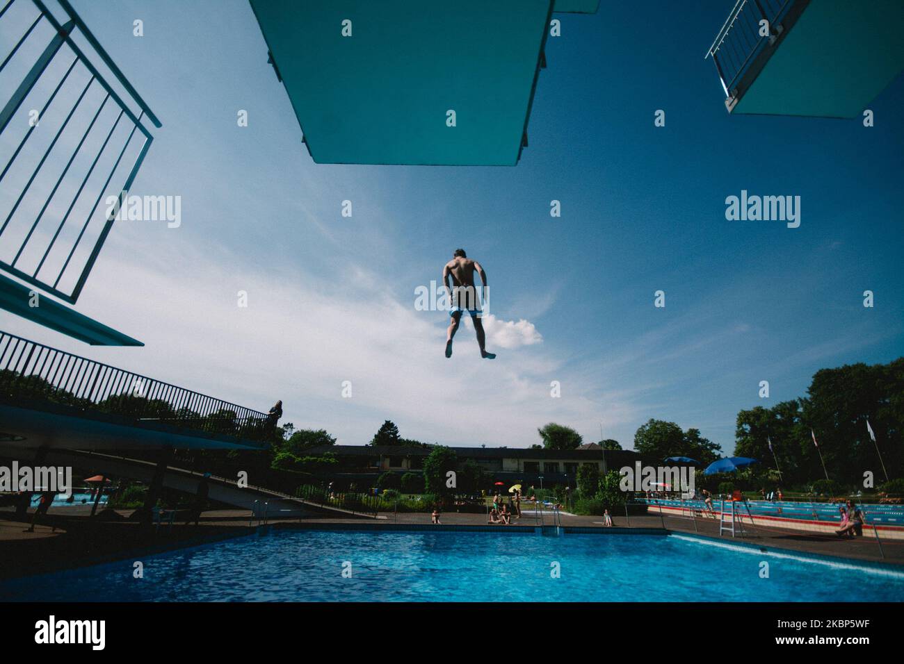 A boy jumps into the water at the reopening day of panoramabad swimming ...