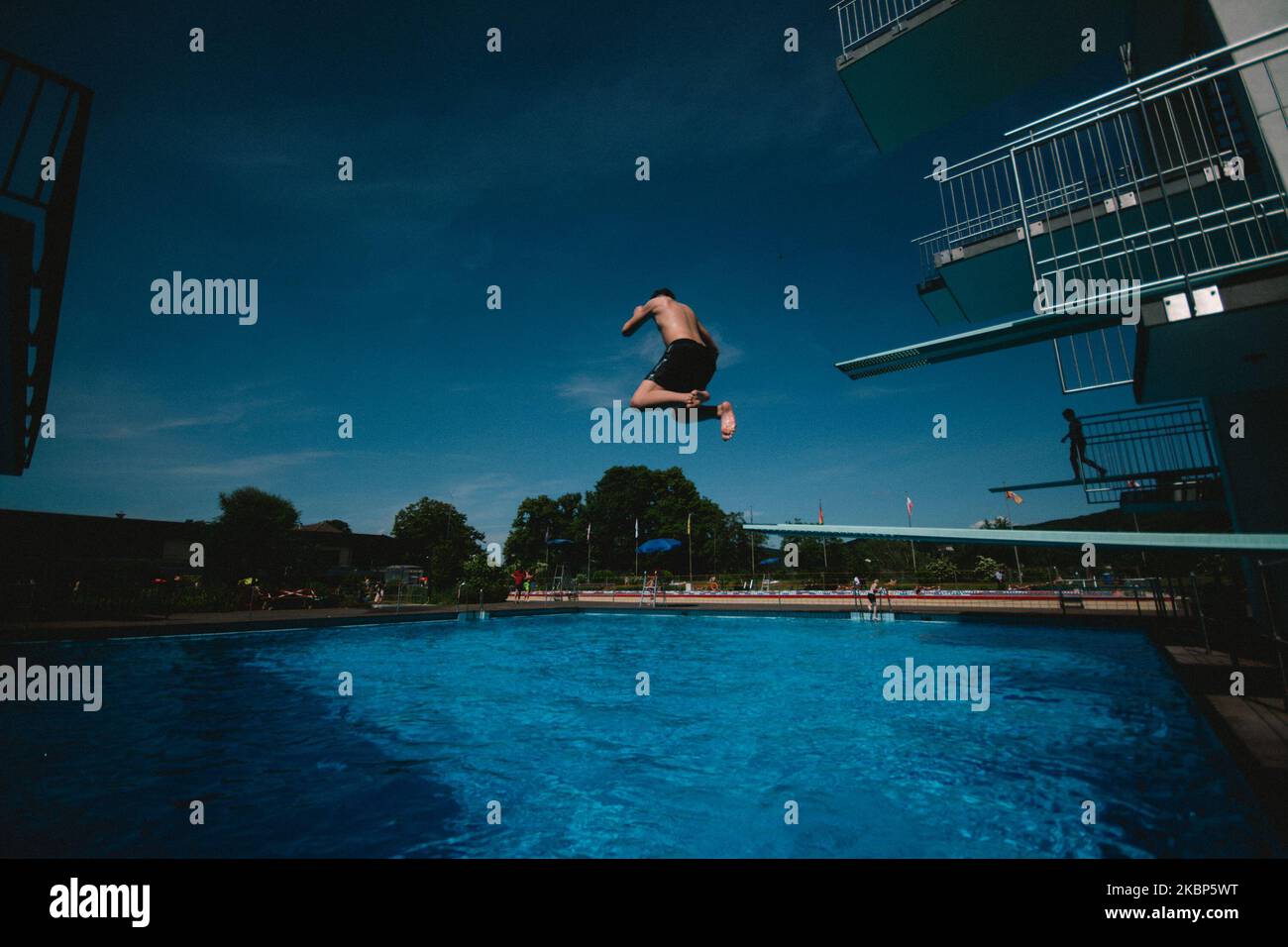A boy jumps into the water at the reopening day of panoramabad swimming ...