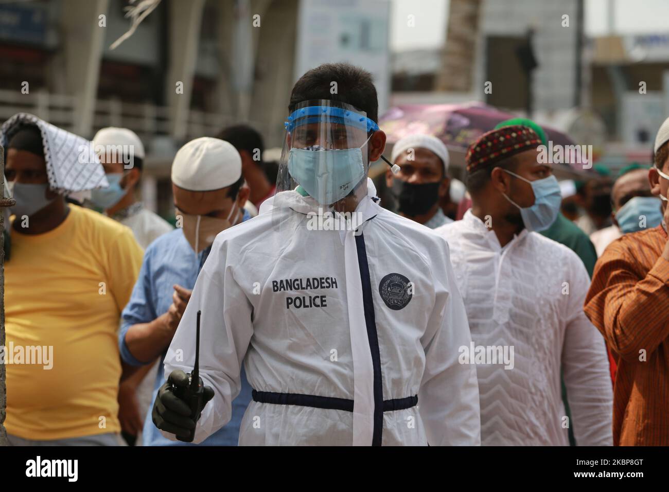 A member of law enforcers wears protective clothes as he stands guard ...