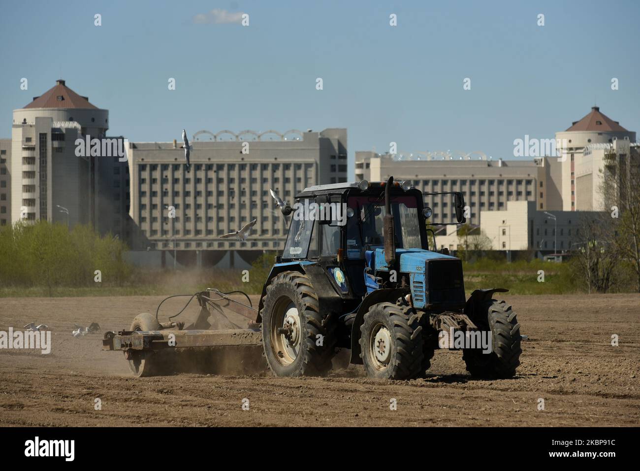 A tractor plows a field opposite the pre-trial detention prison New ...