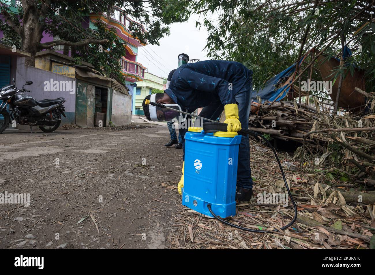 Workers put on a protective suits and masks prior to disinfect a street ...