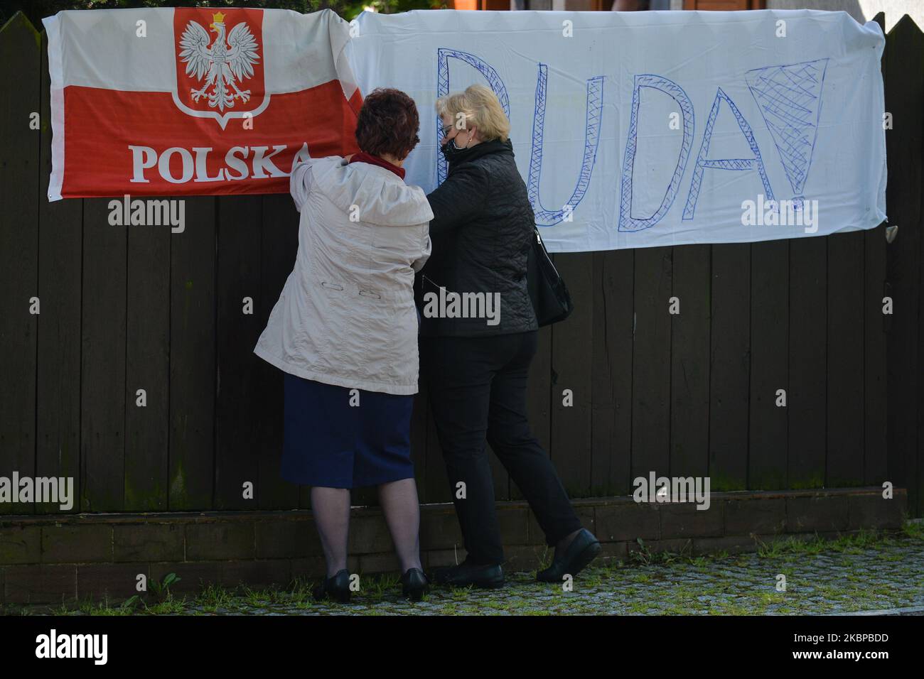 Two ladies are fixing a hand made election poster of Andrzej Duda, the ...
