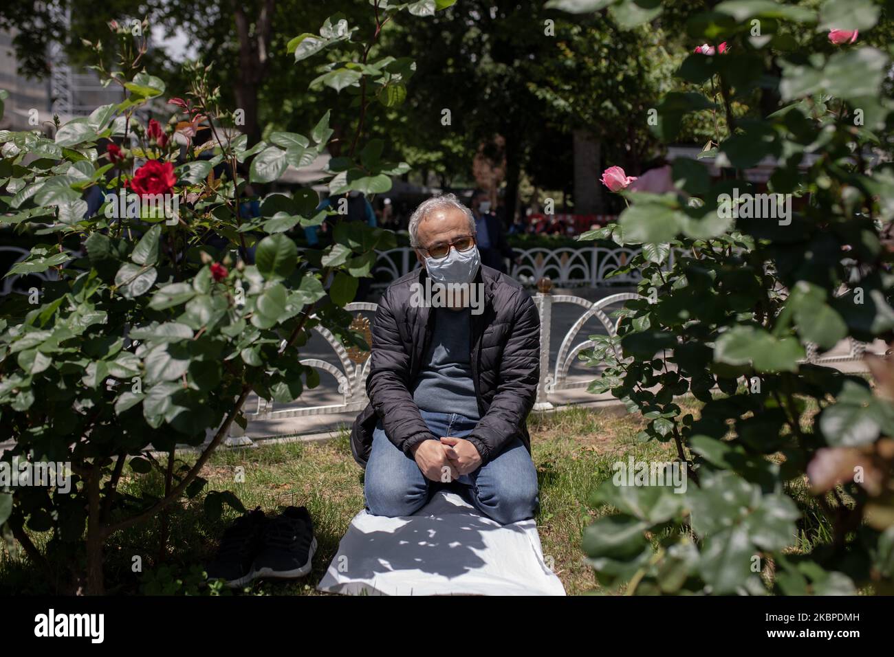 Worshippers wearing protective face masks maintain a required social ...