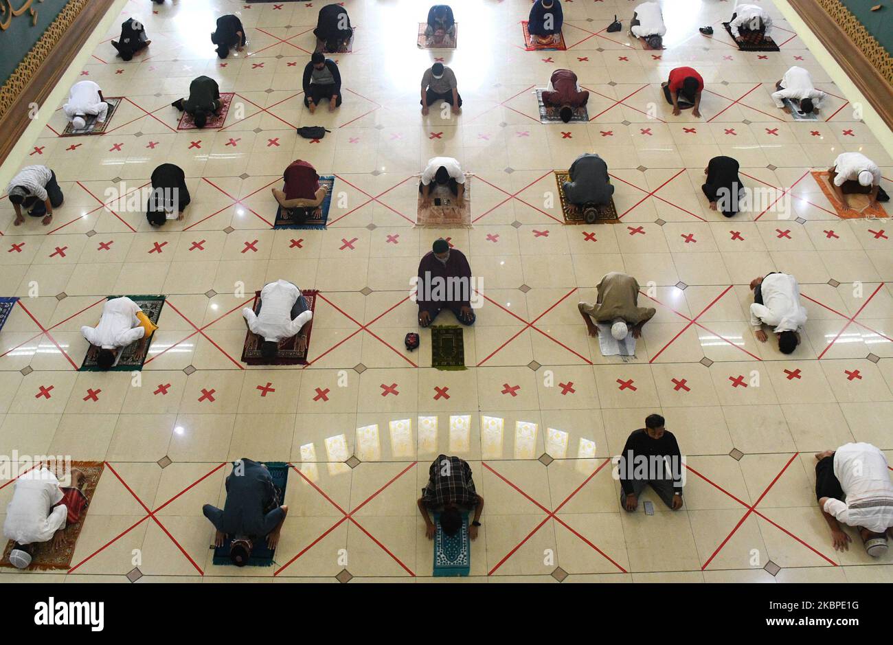 Muslims perform their first Friday prayer at the distance of the Al Barkah Great Mosque in ...
