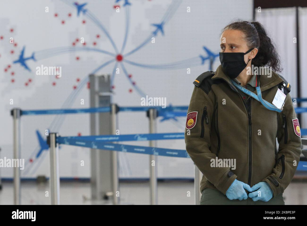 Airpotrt Security Officer wearing face mask and rubber gloves is seen ...