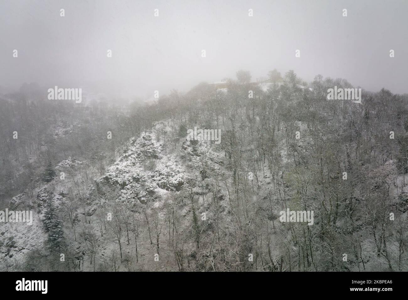 Aerial foggy landscape with mountain cliffs covered with fresh fallen ...