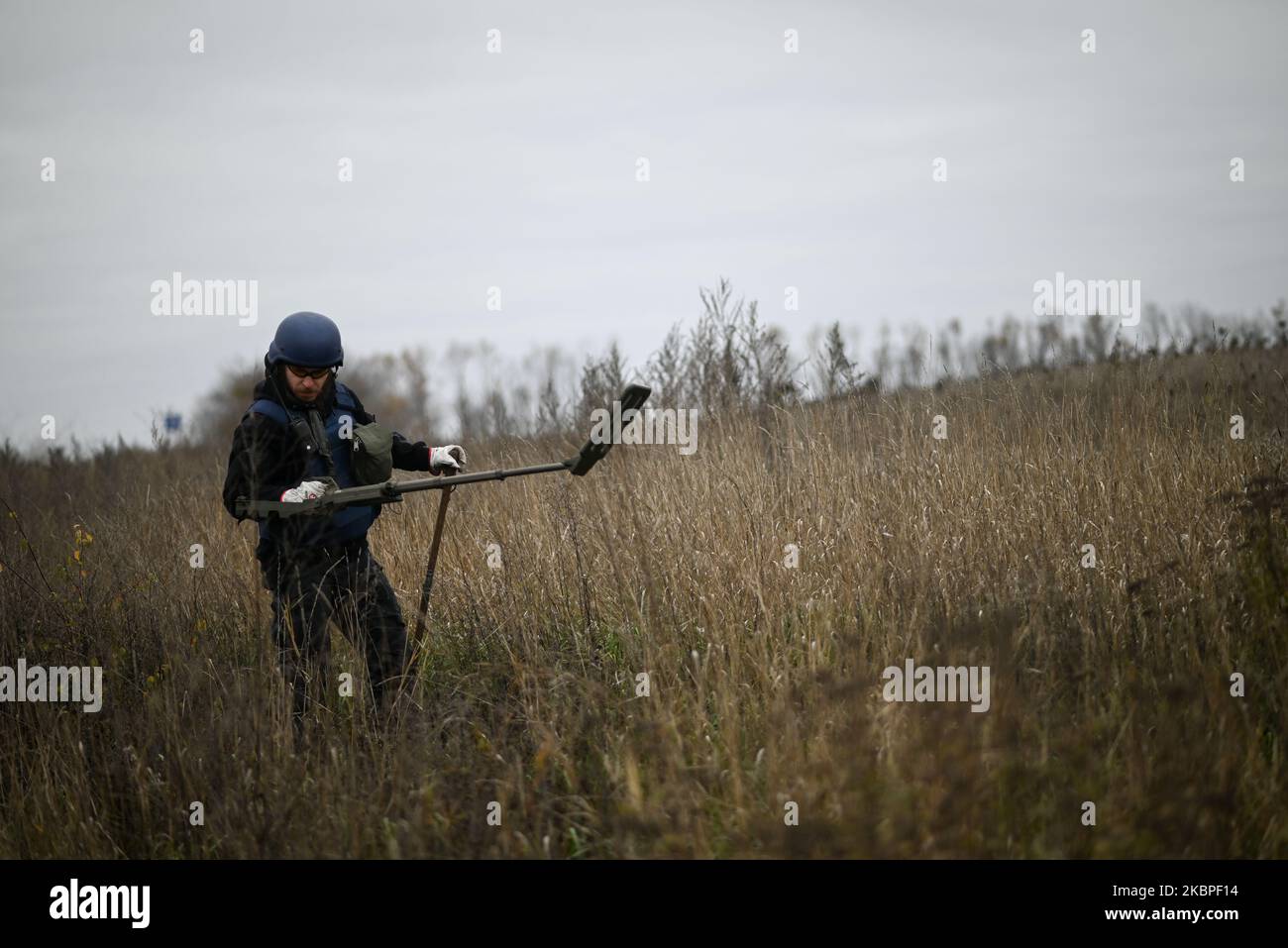 A Ukrainian bomb disposal technician navigates through a minefield ...