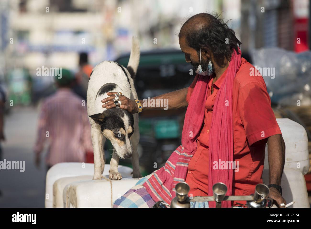 Mr Doyal pulling his rickshaw van, carrying a dog on it in the streets ...