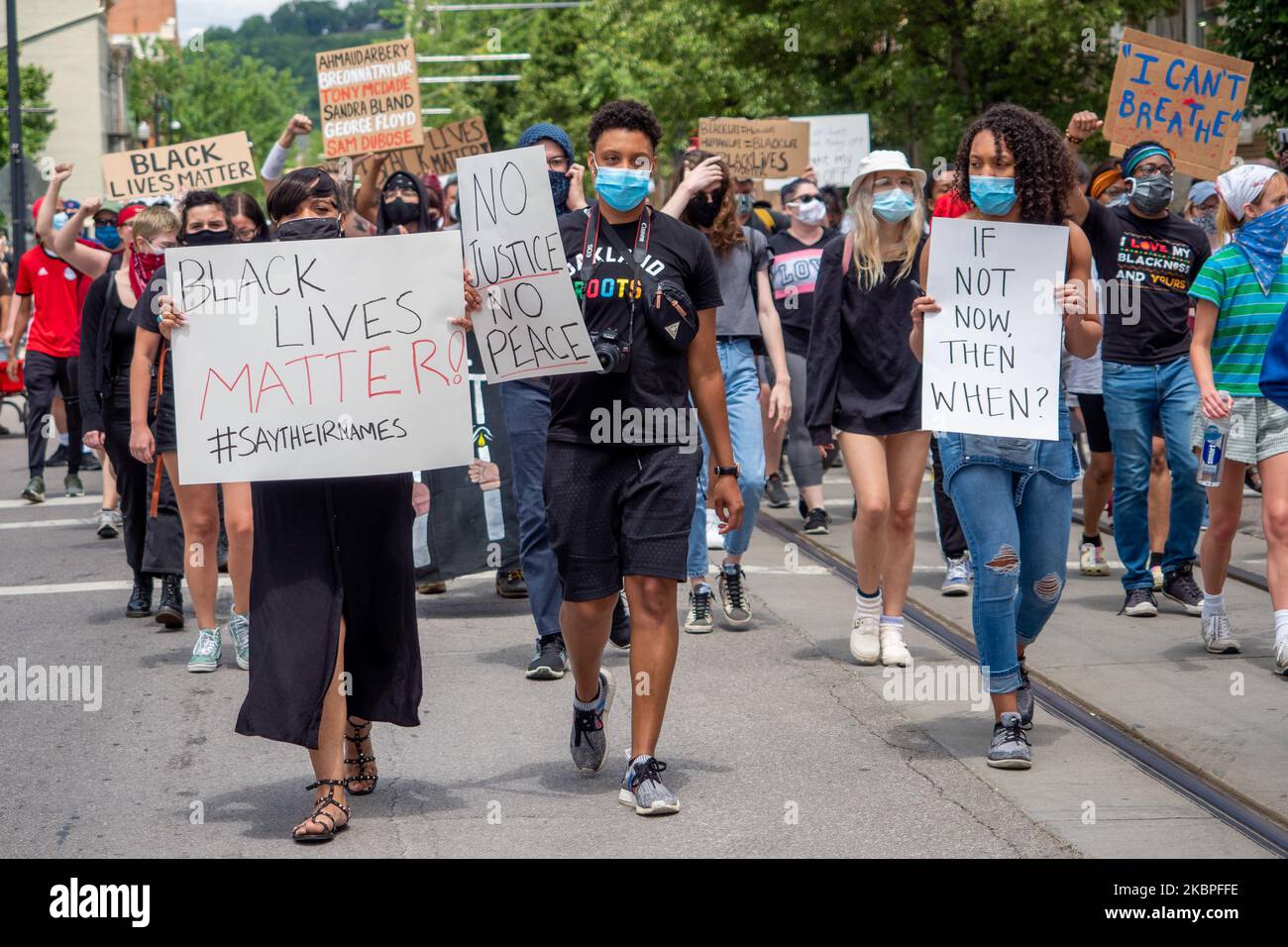 Demonstrators hold up signs during a Mass Action for Black Liberation ...