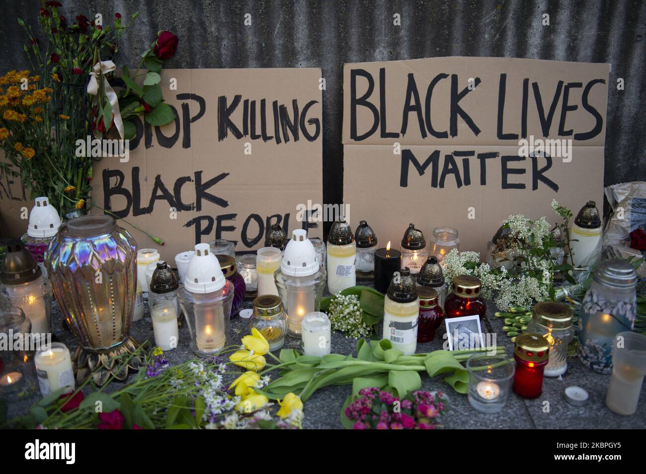 Lit candles, flowers and signs are seen in front of the US embassy in ...