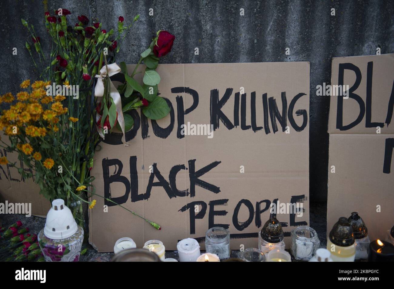 A sign and flowers lay against the wall of the US embassy in Warsaw ...