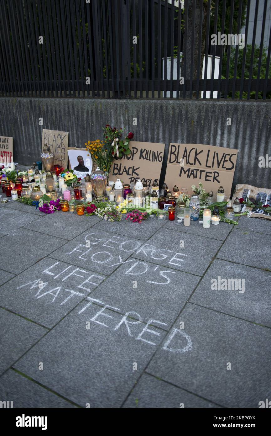 Lit candles, flowers and signs are seen in front of the US embassy in ...