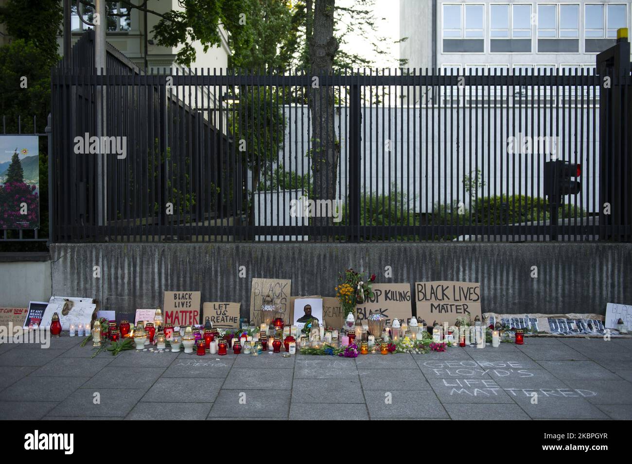 Lit candles, flowers and signs are seen in front of the US embassy in ...