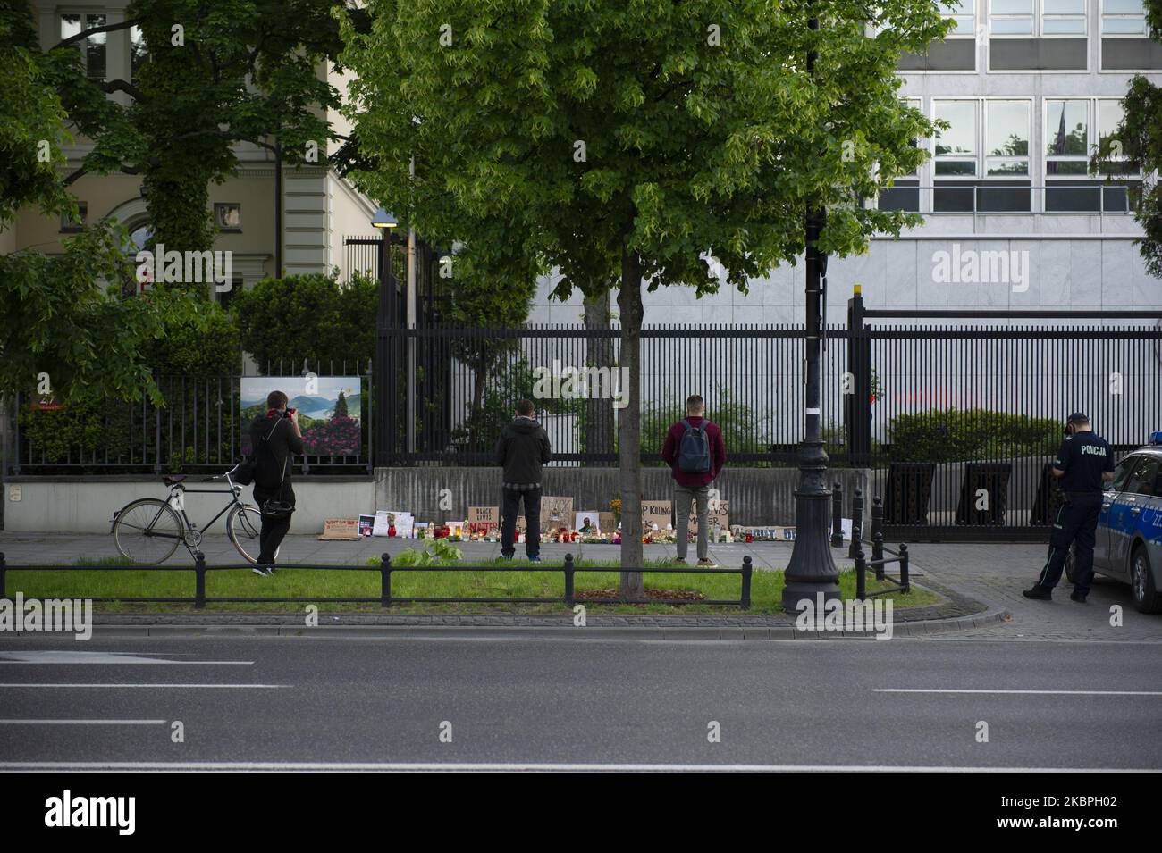 Mourners look at lit candles and flowers layed in front of the US ...