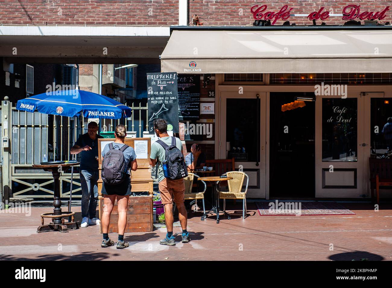A couple are following the rules before take a table in a terrace ...