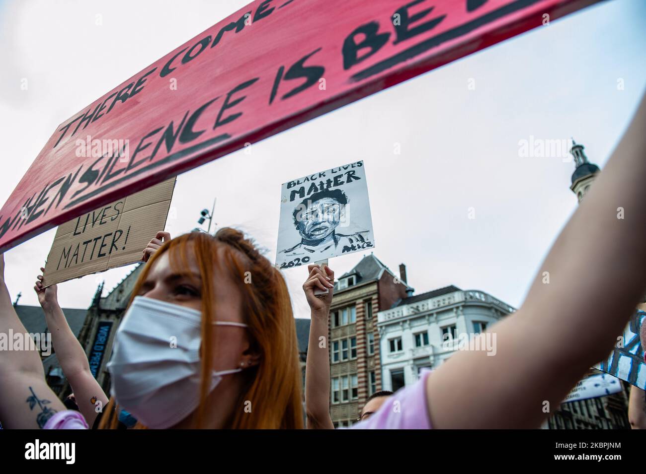 A woman is holding a big placard over her head, during the massive ...