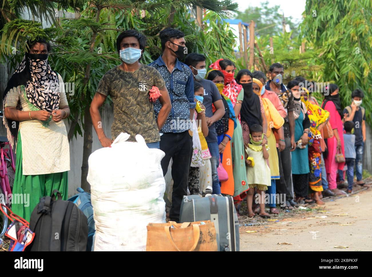 Migrant labourers waits for bus to go their native place return from ...