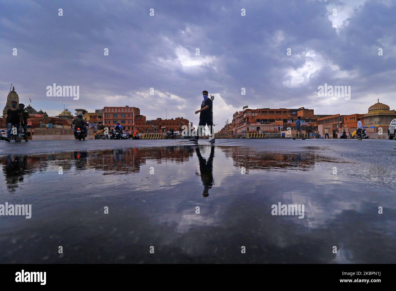 A man walk on a city road during rainfall at Badi Chaupar in Jaipur ...