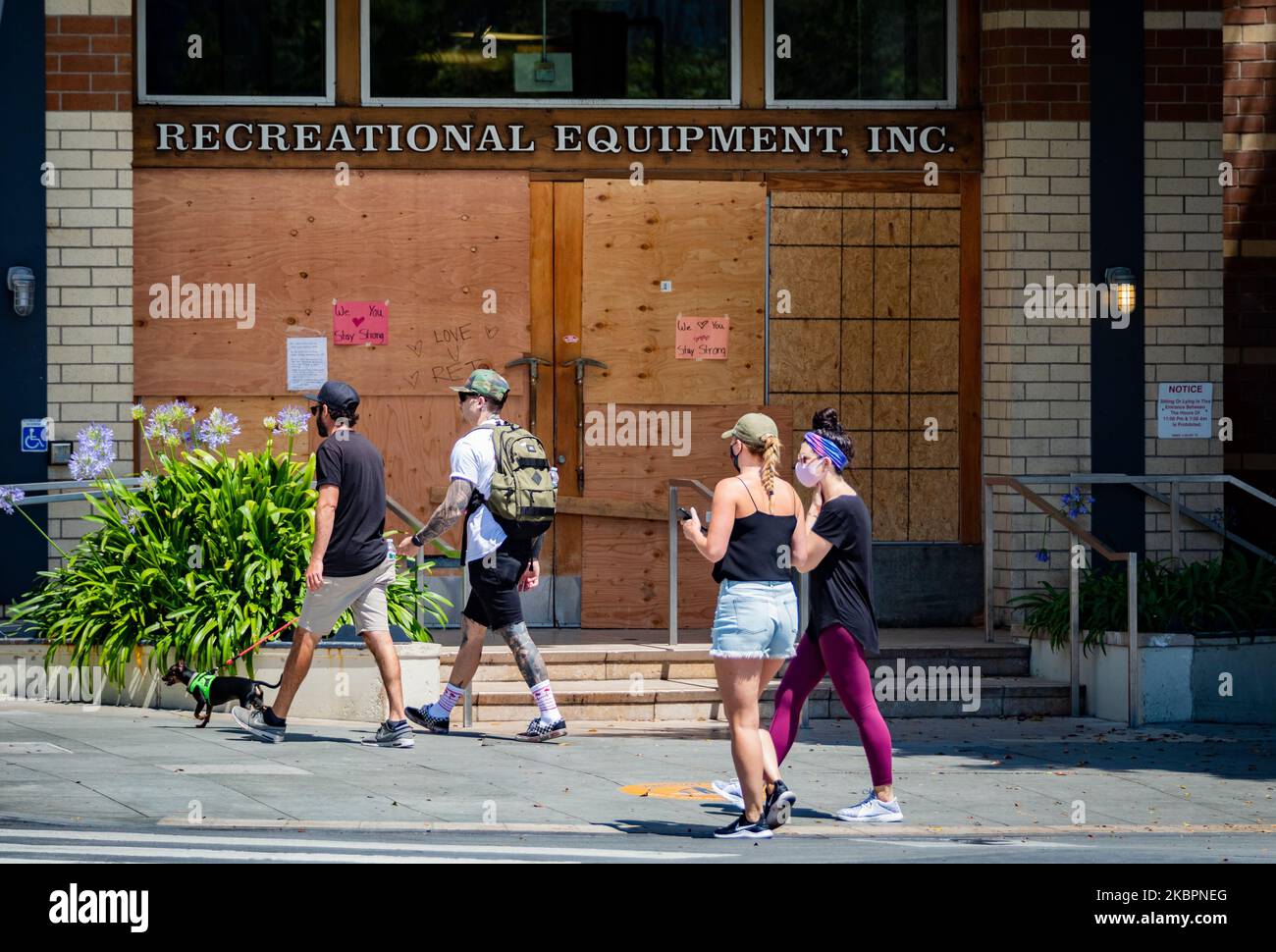 An REI store shop window shop remains boarded up after looting occurred ...