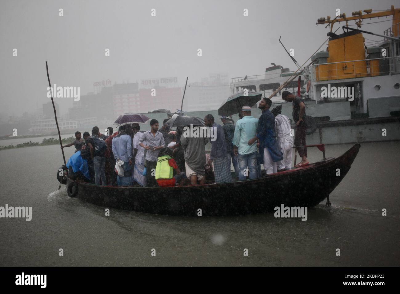 People cross the river Buriganga through boat during a heavy rainfall ...