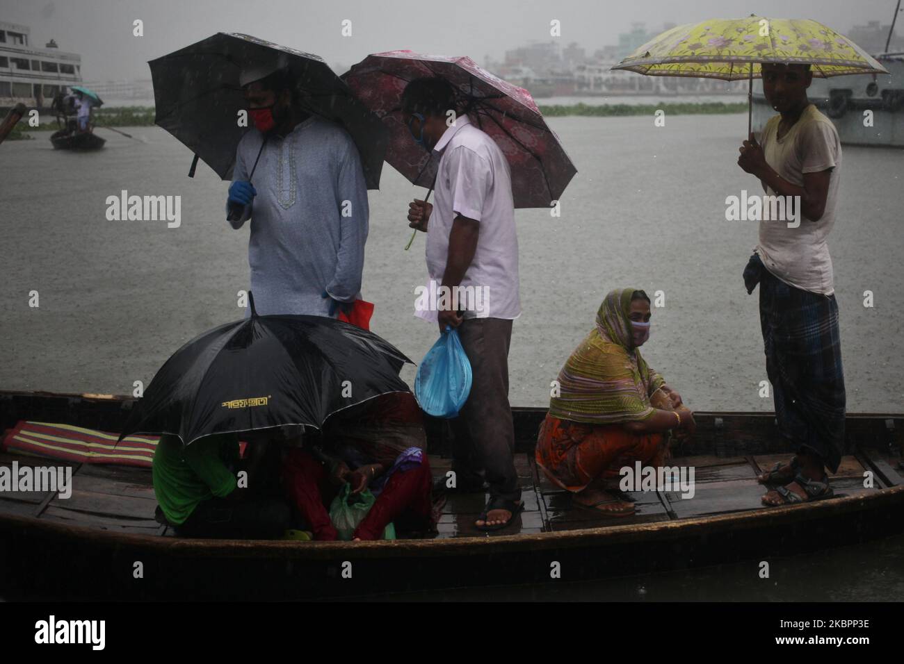 People cross the river Buriganga through boat during a heavy rainfall ...