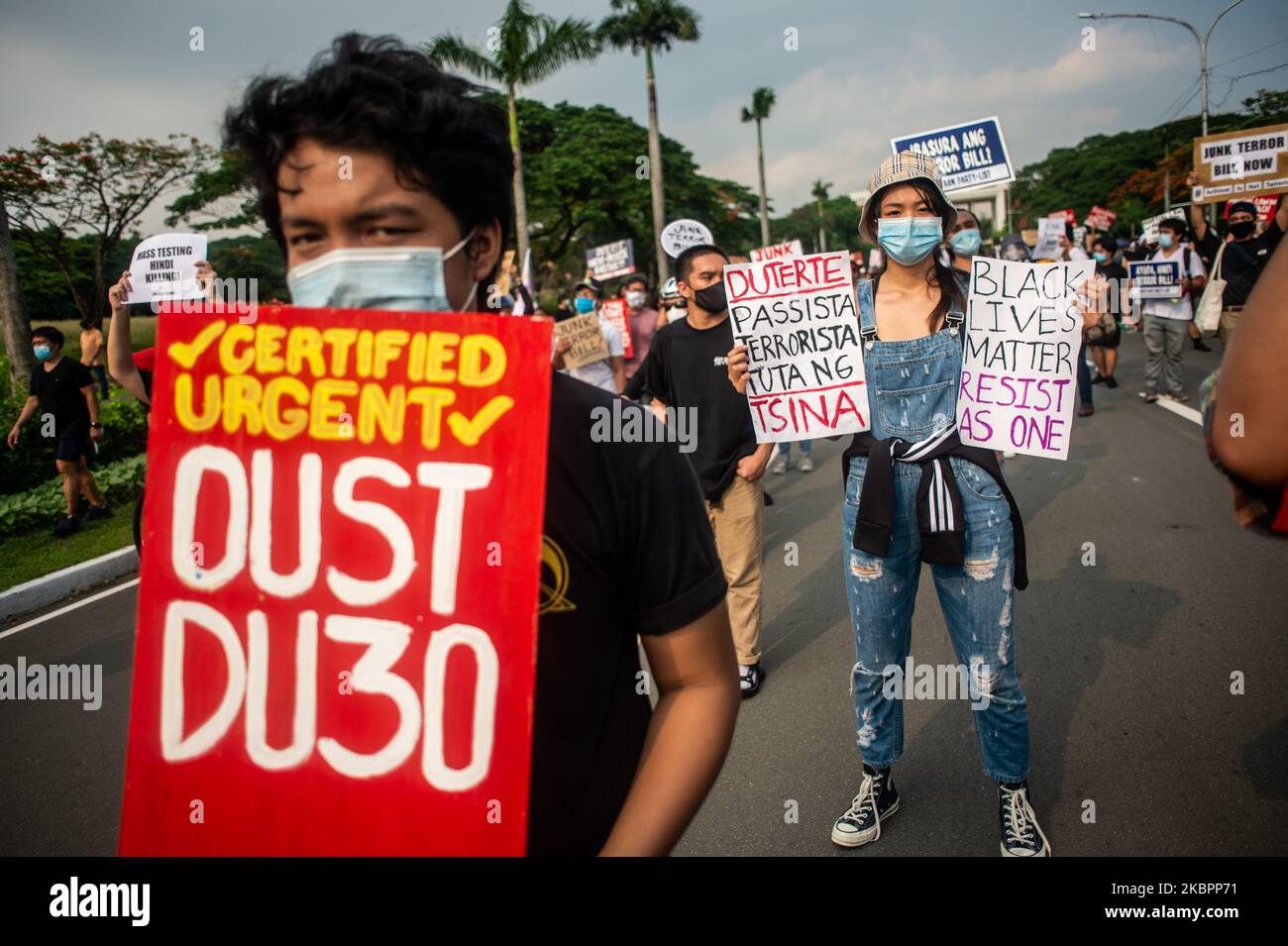 A woman carrying a placard which reads "Duterte Fascist Terrorist ...